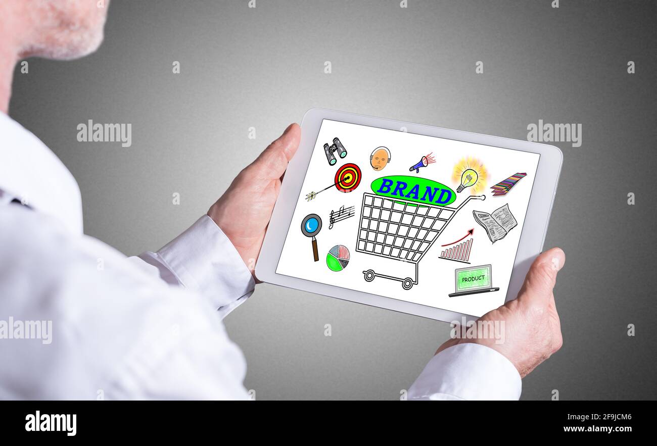 Man holding a tablet showing brand concept Stock Photo - Alamy