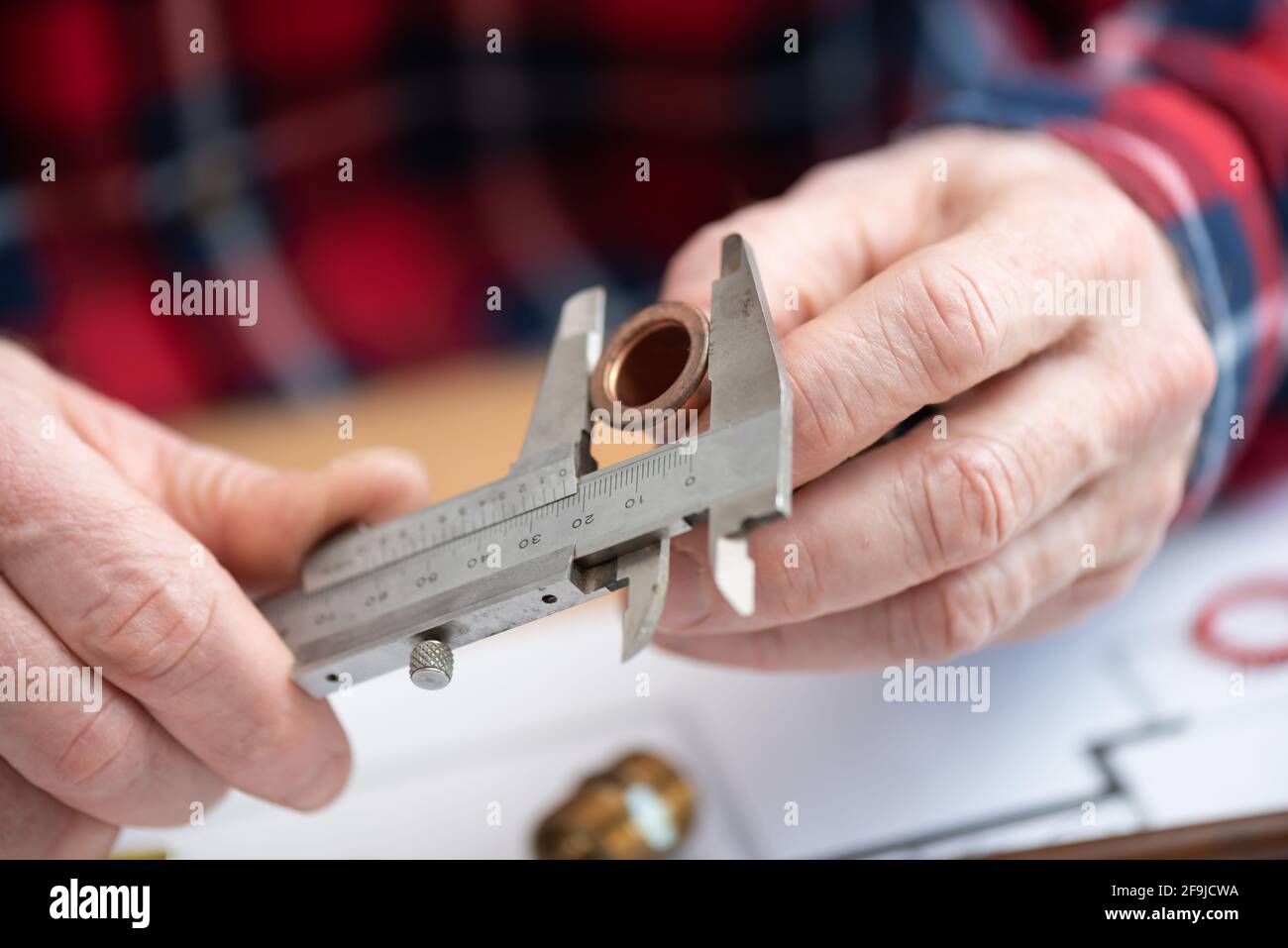 Plumber measuring a copper tube with a caliper Stock Photo - Alamy