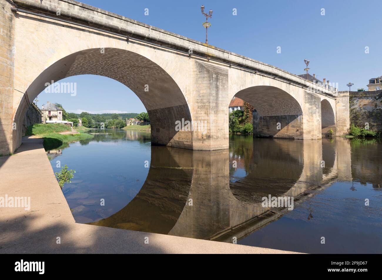 An old stone bridge over the Vézère River, and its reflection, in ...