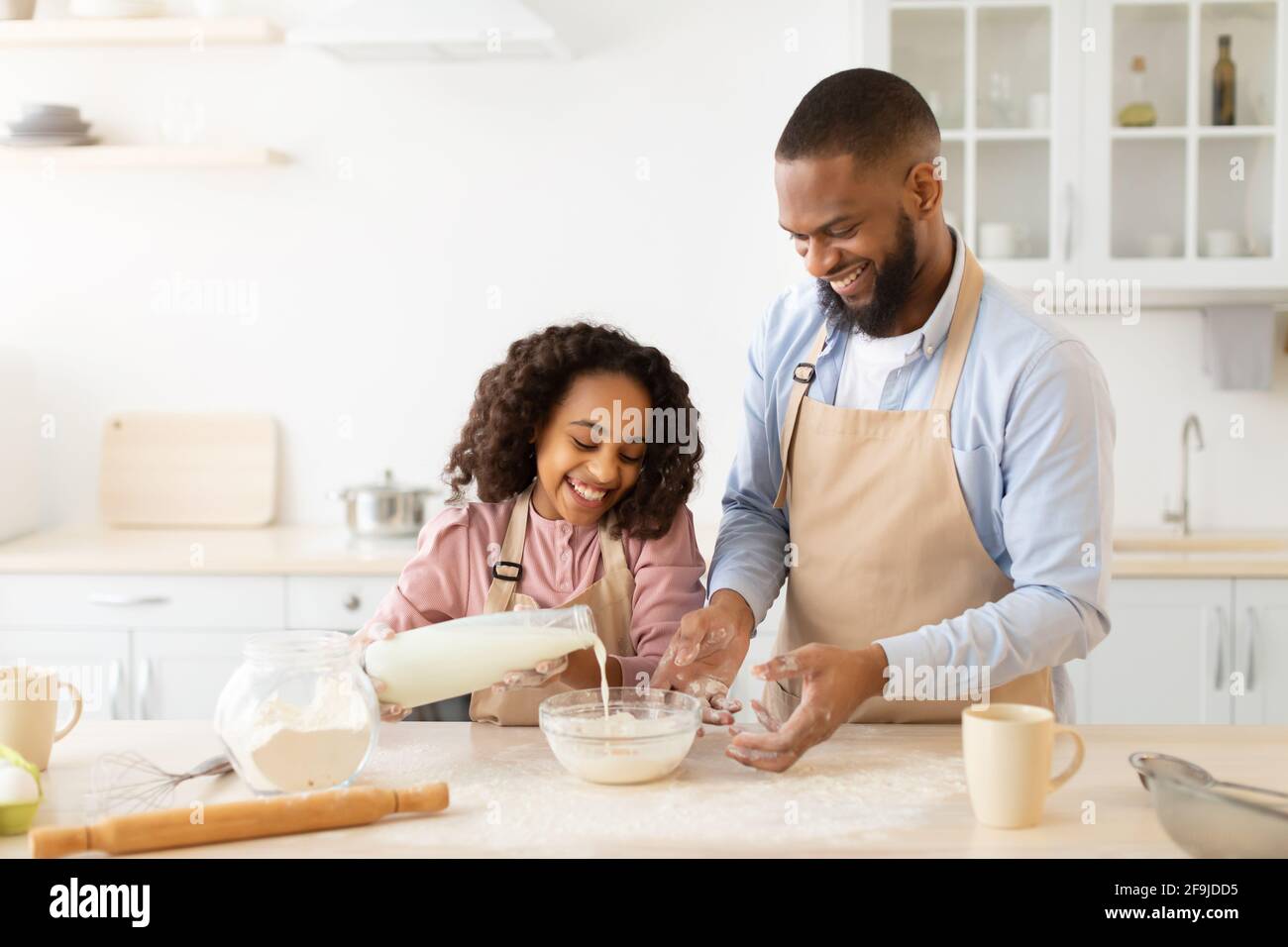 Happy afro family preparing dough together in kitchen Stock Photo - Alamy