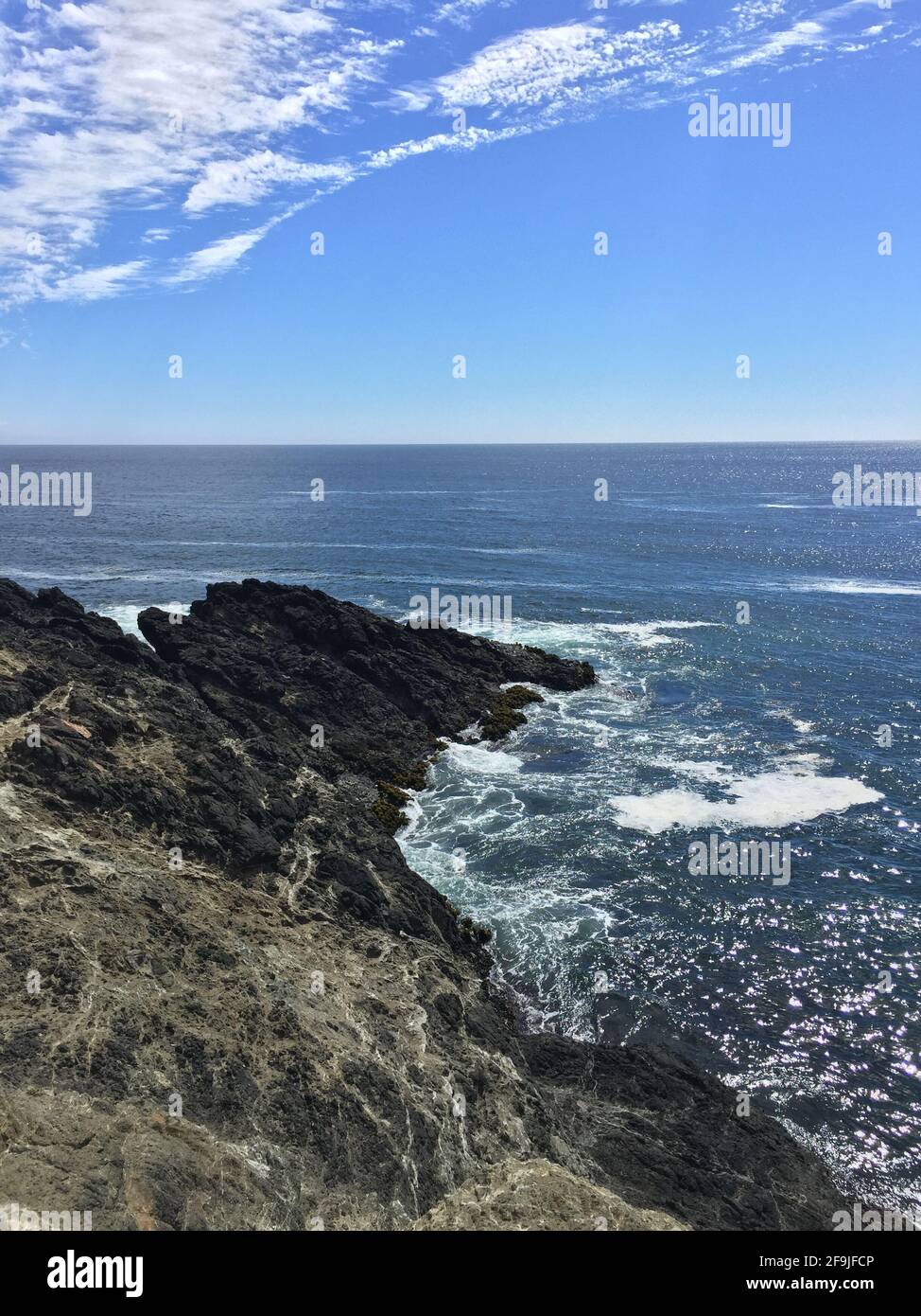 Pacific Ocean coastline near Fort Bragg, California under wispy clouds ...