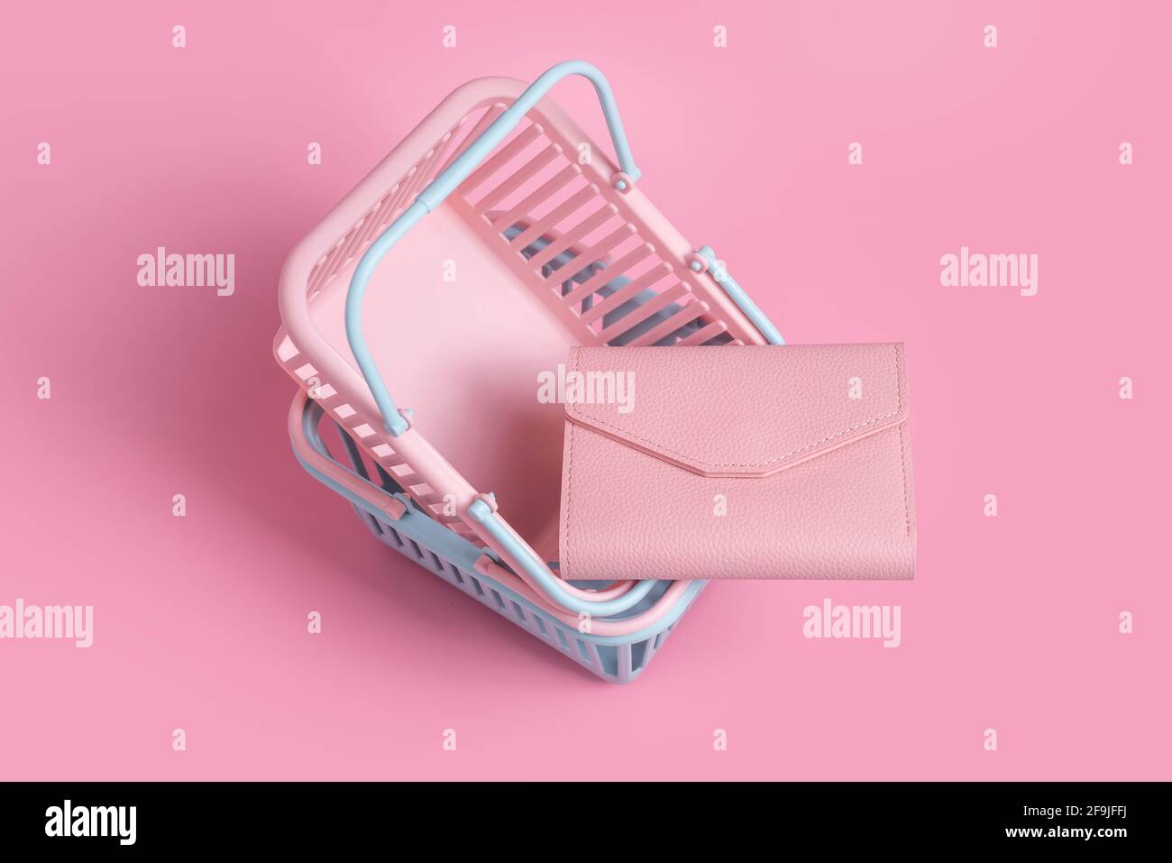 Colorful plastic shopping baskets with leather wallet. Empty pink and ...