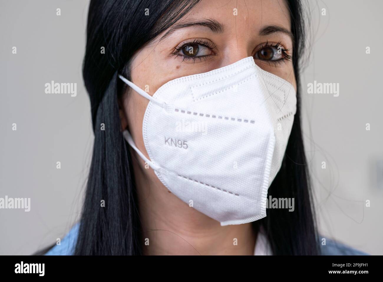 Portrait of a young woman wearing a face mask to protect against ...