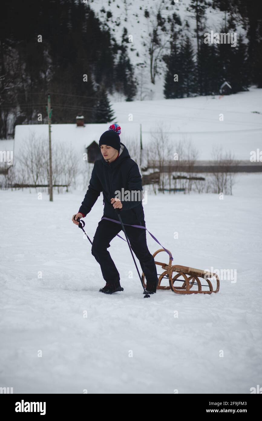 Climber pulls to top of wooden sled for ride on the piste. Going back ...