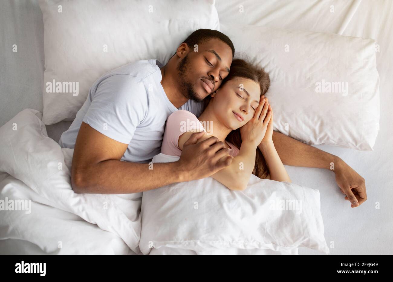 Loving multiracial couple having cozy morning, cuddling together in ...