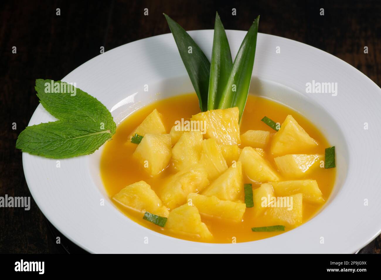 Fresh pineapple dessert recipe with mint orange coulis Stock Photo - Alamy