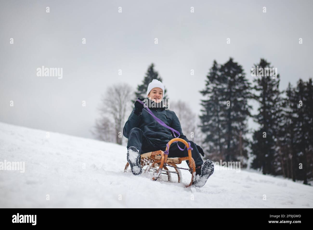Joyful smile of a young sixteen year old boy riding a historic wooden ...