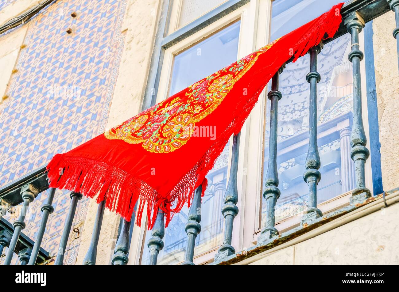Low angle shot of a red manila shawl in a balcony in Rua da Prata ...