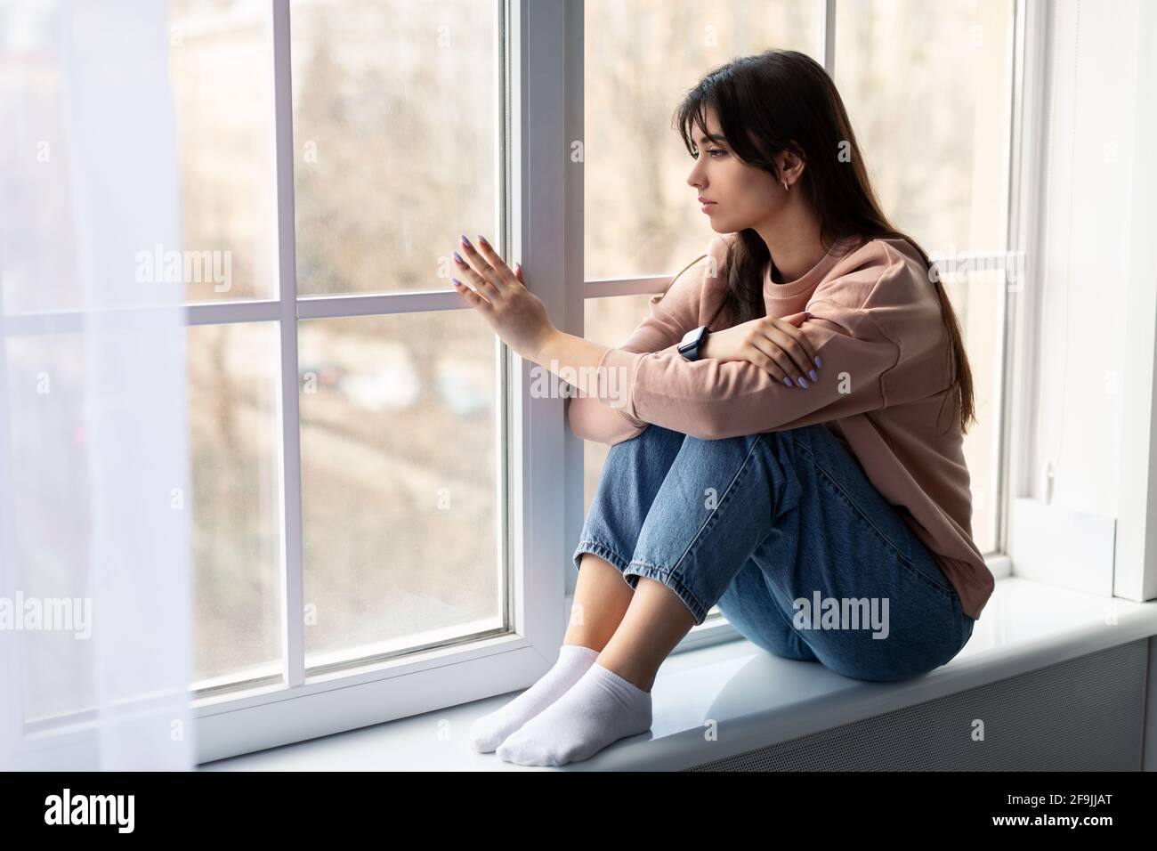 Sad young woman window hi-res stock photography and images - Alamy