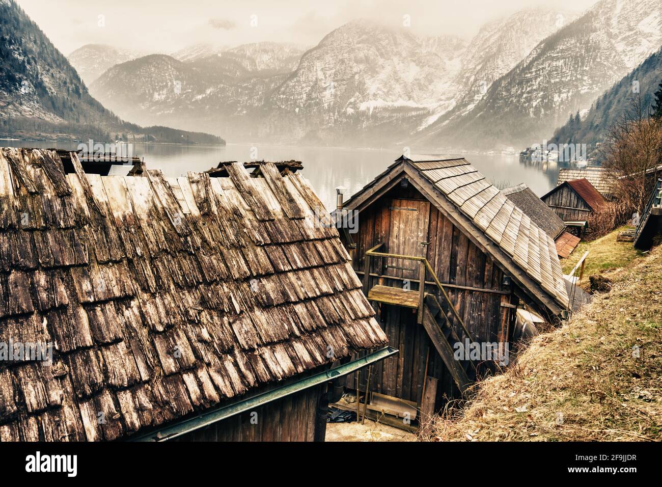 Traditional buildings in Hallstatt with misty mountains in the ...