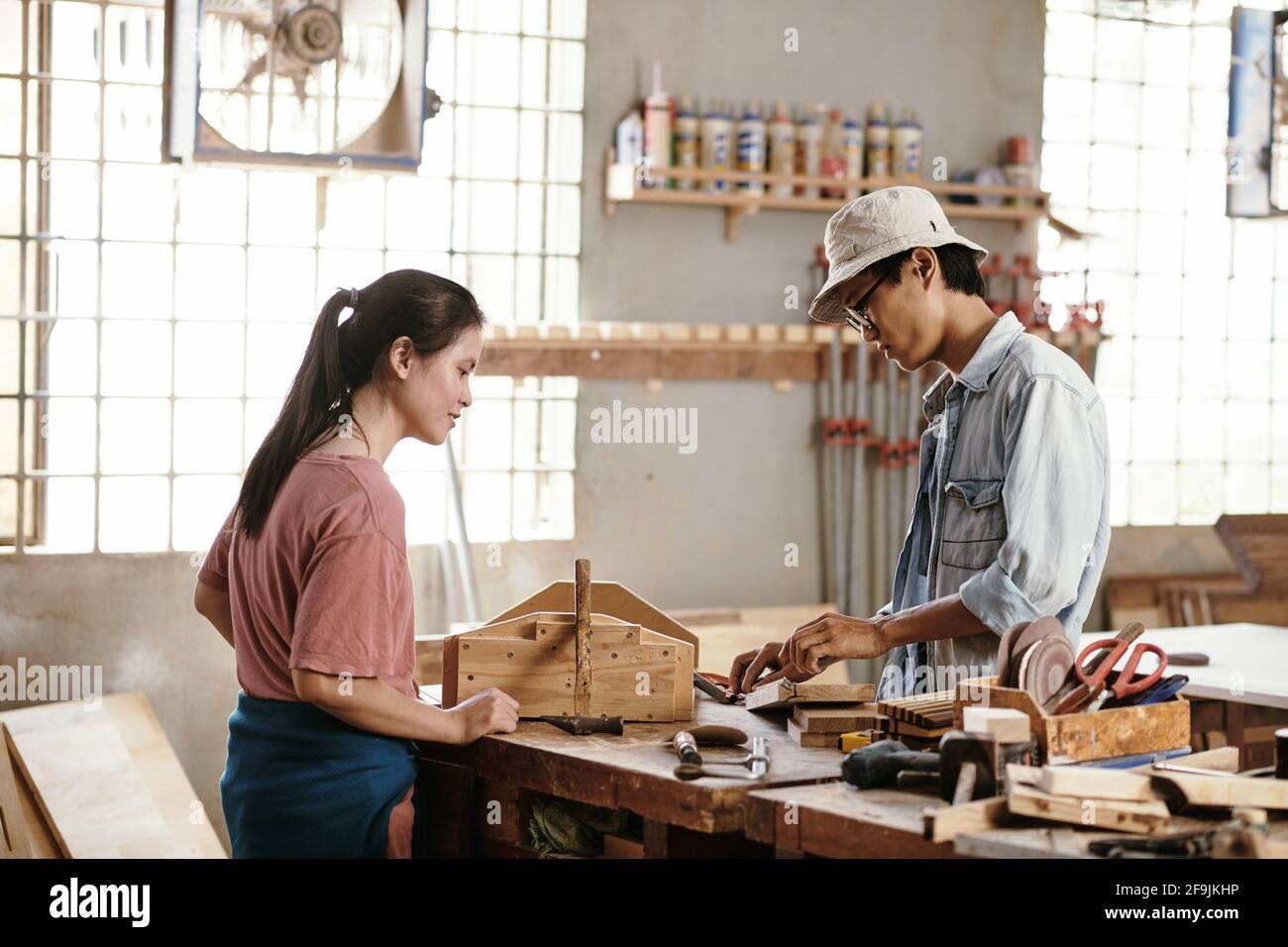 Young Vietnamese carpenters working with wooden planks and blocks at ...