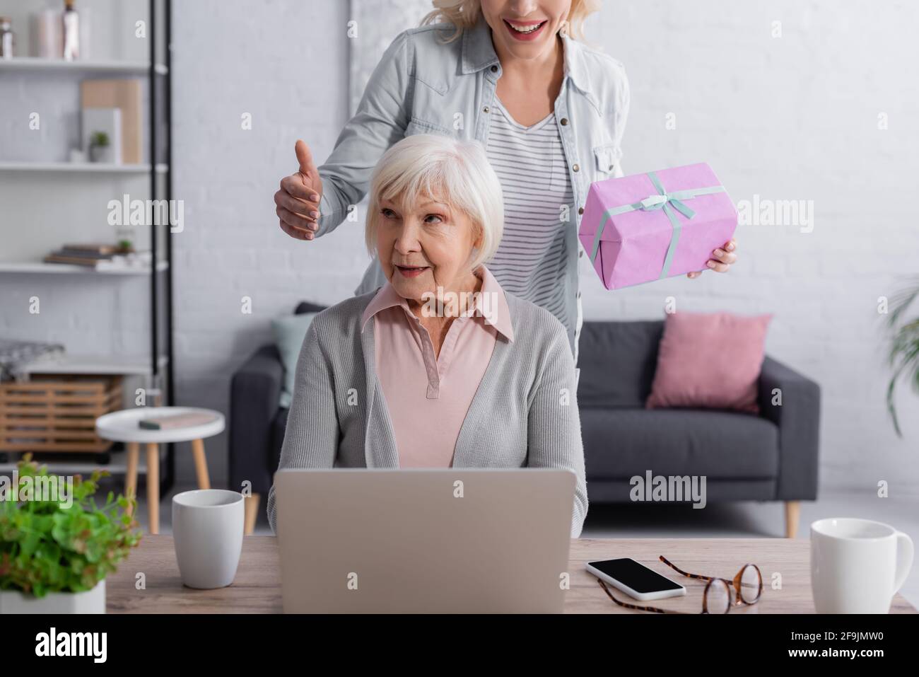 Smiling woman holding present hi-res stock photography and images - Alamy