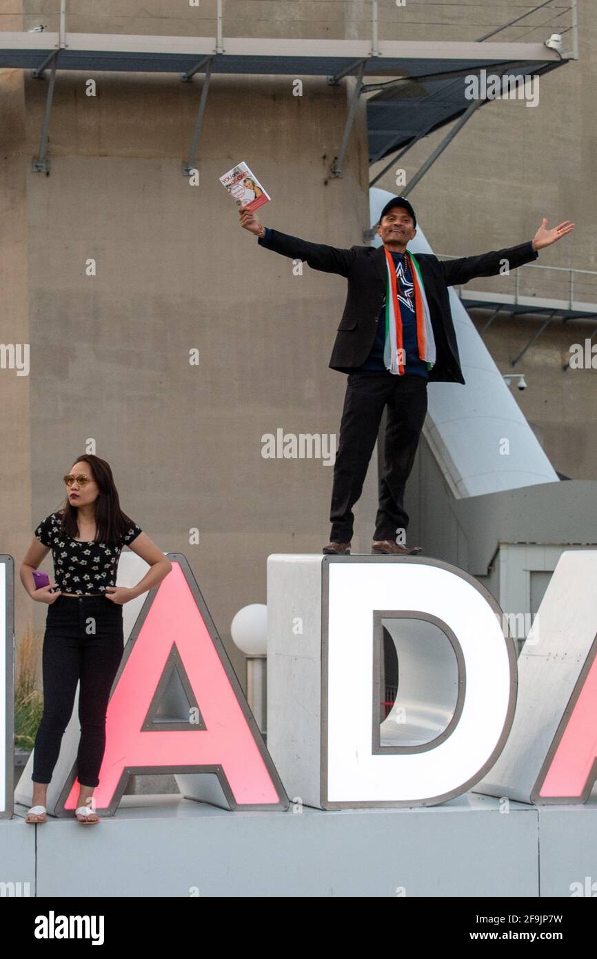 People advertising on the Canada 150 anniversary sign at the base of ...