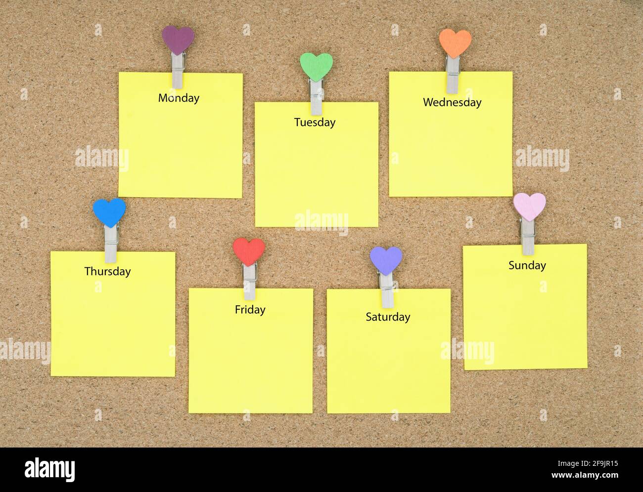 Seven yellow sticky notes with days of the week on a cork board Stock ...