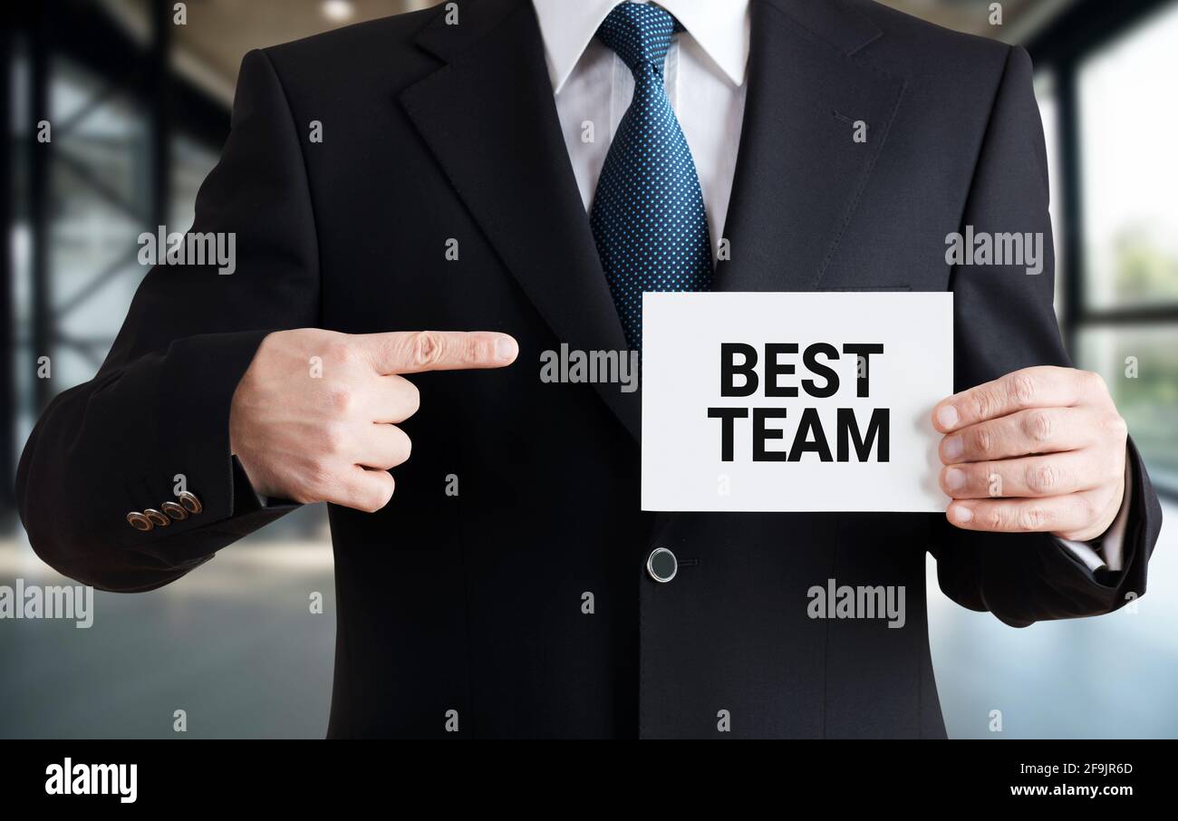 Businessman shows a card with the message best team. Business teamwork ...