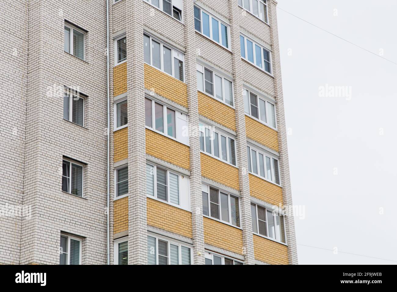 Facade of a high-rise building with plastic windows and balconies ...