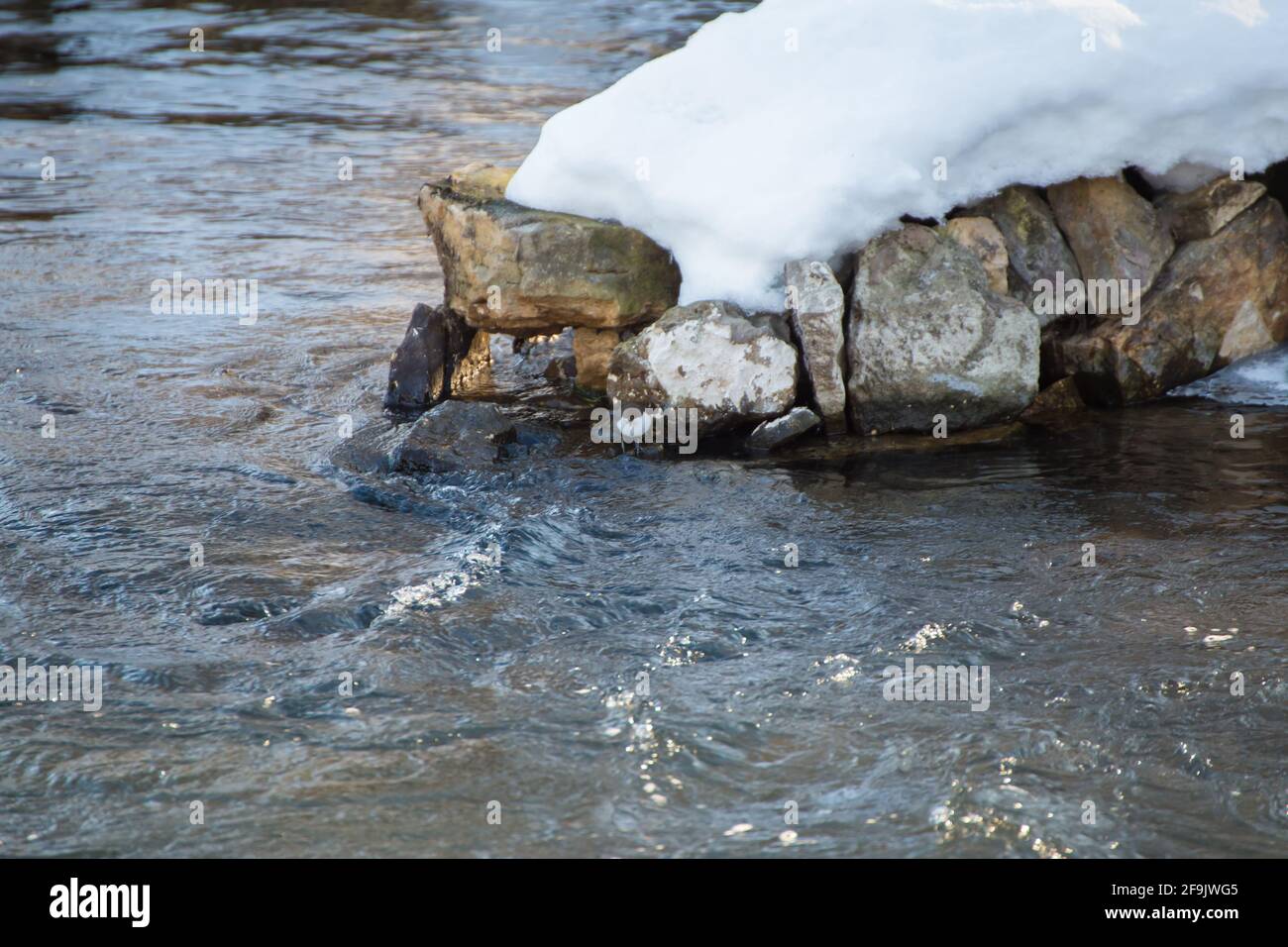 Winter landscape of a river with seething water and snow-capped rocky ...
