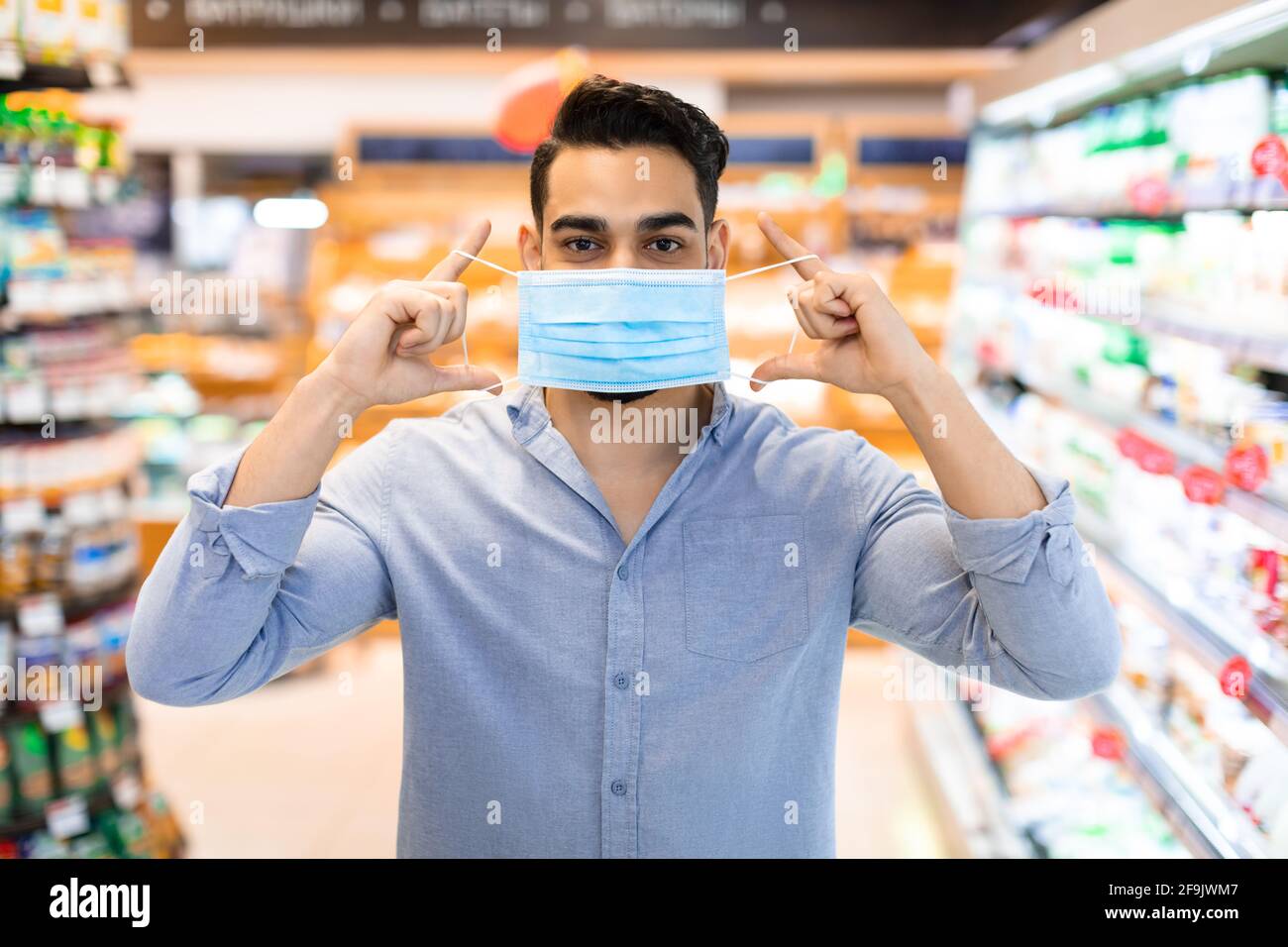 Middle-Eastern Man Showing How To Wear Face Mask In Supermarket Stock ...