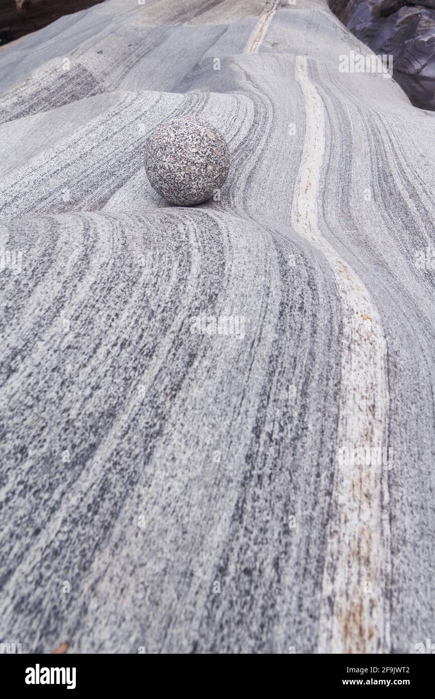 Close-up of one round stone on grey granite stone waves made by crystal ...