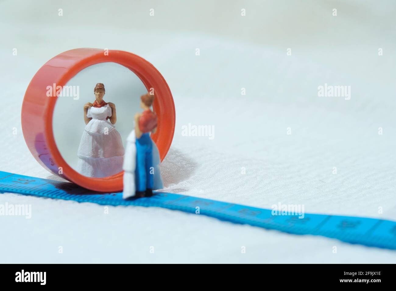 Women miniature people standing above measuring tape to fix her wedding ...