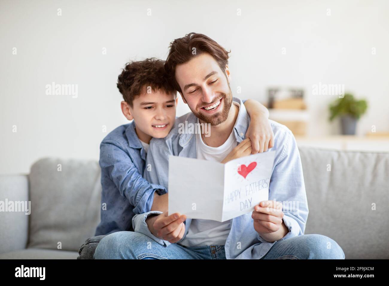 Father's day concept. Son congratulating daddy and giving him handmade ...