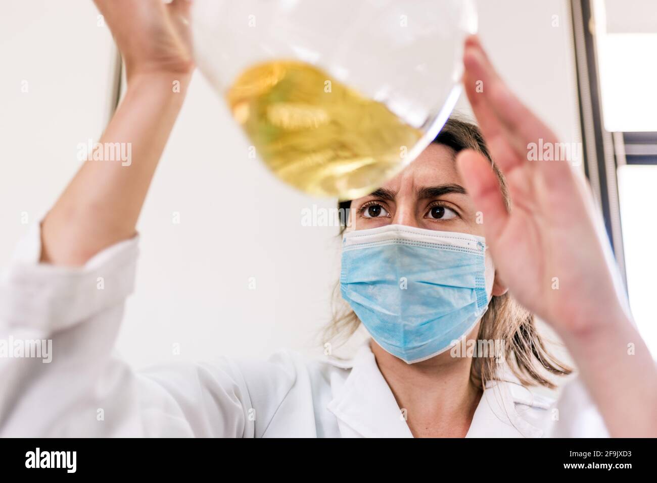 Stock photo of female scientist wearing face mask working in the ...