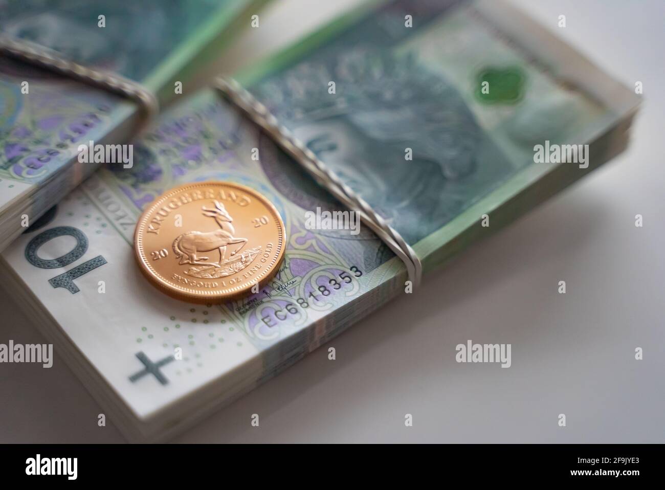 View on shiny investment coin laying on bundle of banknotes. Selective ...