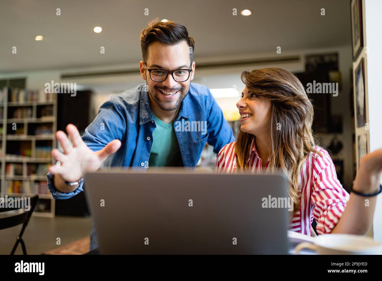 Happy young people working together on laptop. Teamwork, study ...