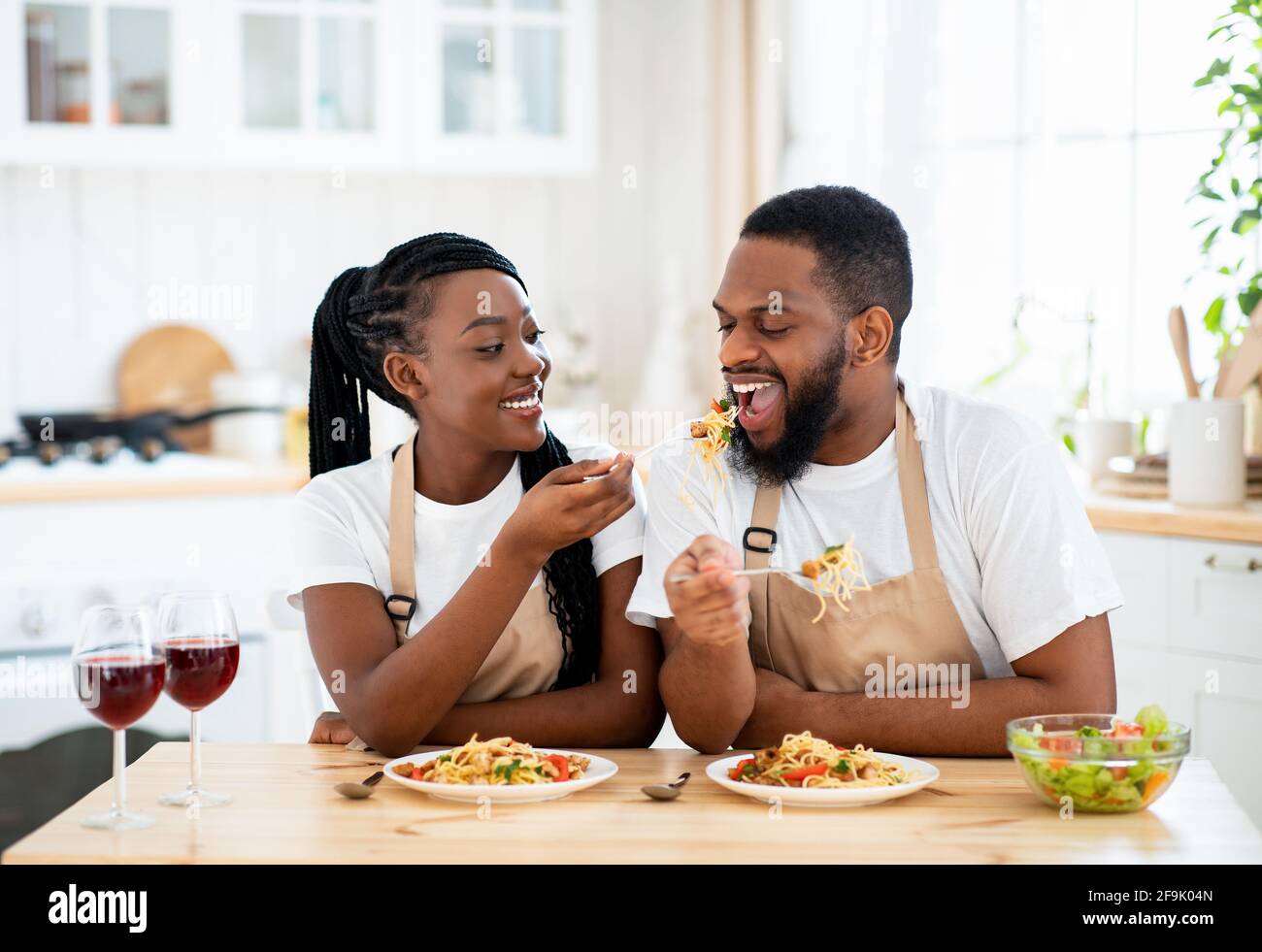 Happy Black Spouses Eating Lunch At Home, Enjoying Spaghetti And Wine ...