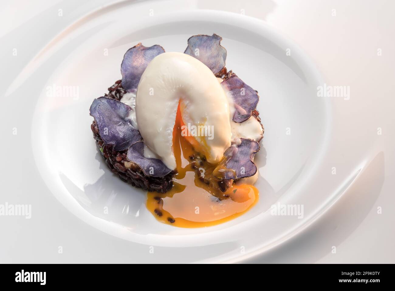 Poached egg with split open, with liquid red yolk Stock Photo - Alamy