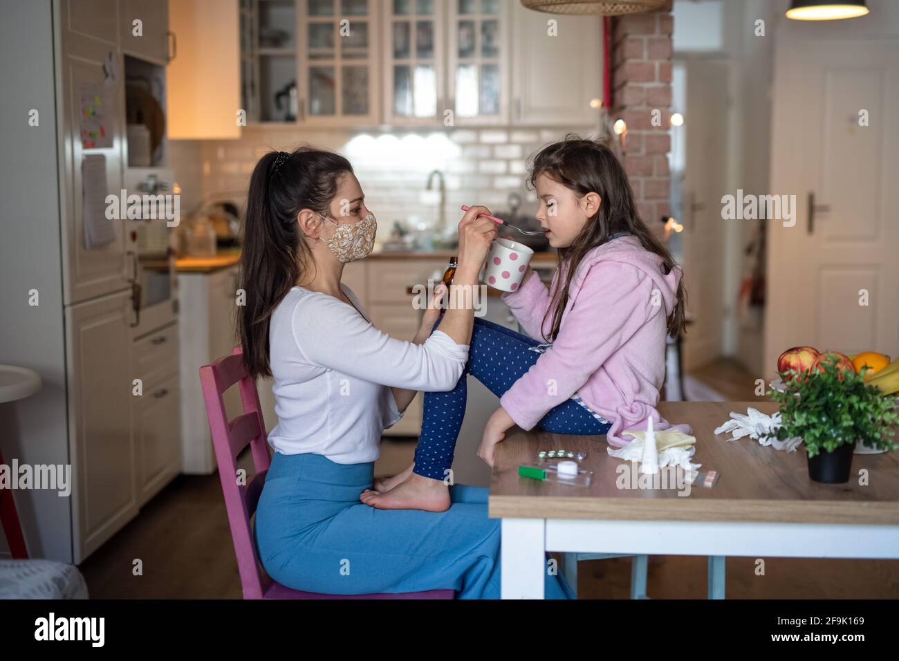 Mother looking after sick small daughter at home Stock Photo - Alamy