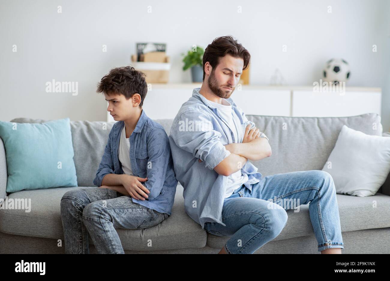Family conflict concept. Father and his son sitting after quarrel back ...