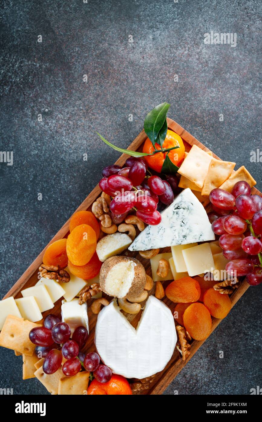 Big cheese board with appetizer assortment. Grape, cheese, nuts, jam ...