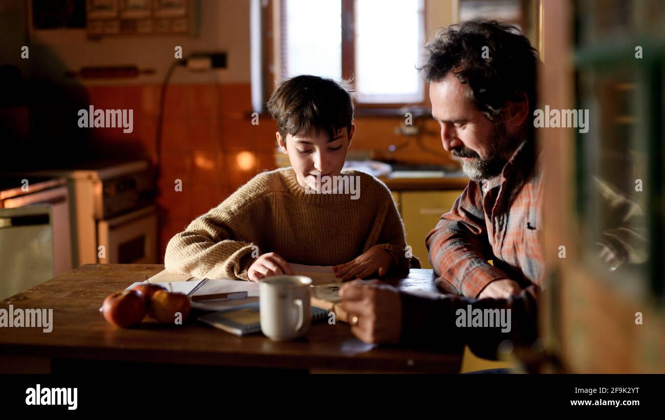 Poor mature father and small daughter learning indoors at home, poverty ...