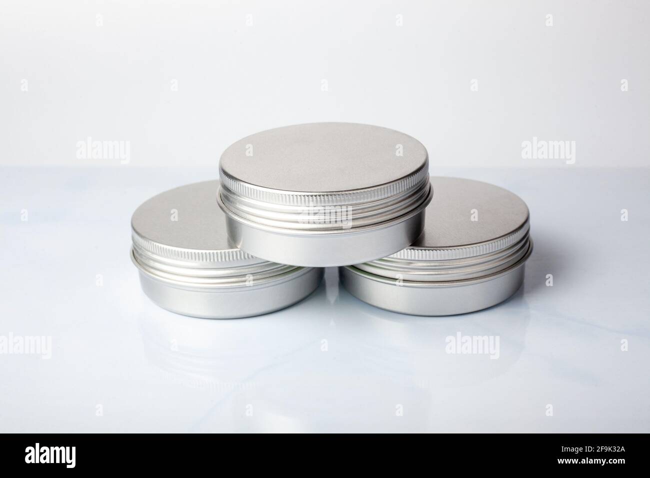 Three metal jars of cream on white background. Aluminum pot for natural ...