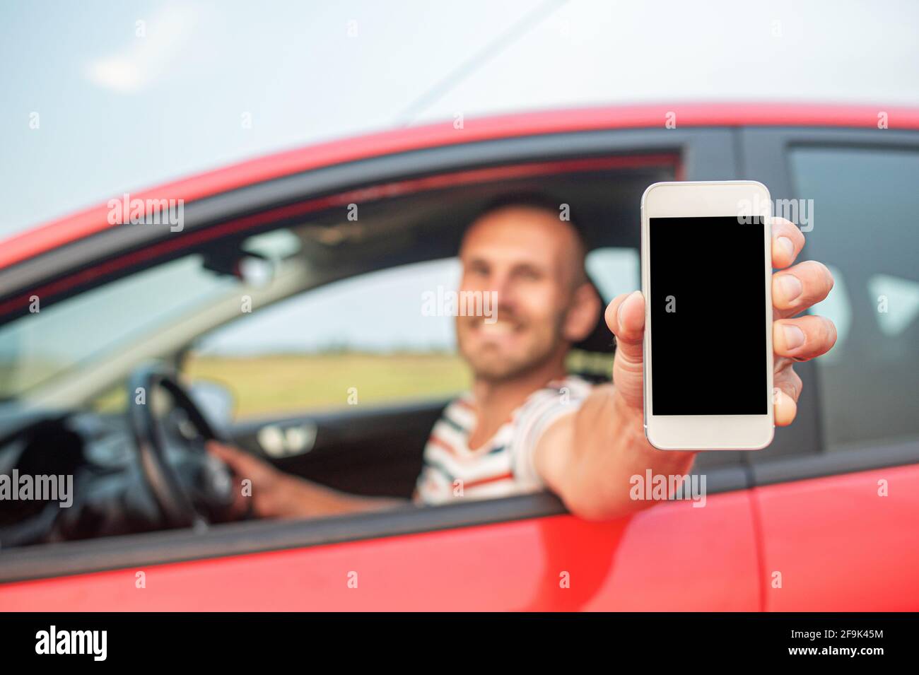The driver shows a smartphone with a blank screen Stock Photo - Alamy
