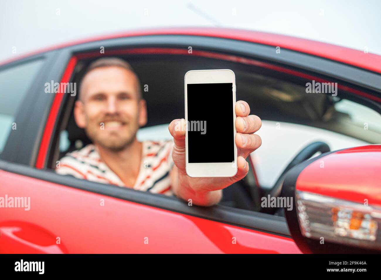 The driver shows a smartphone with a blank screen Stock Photo - Alamy