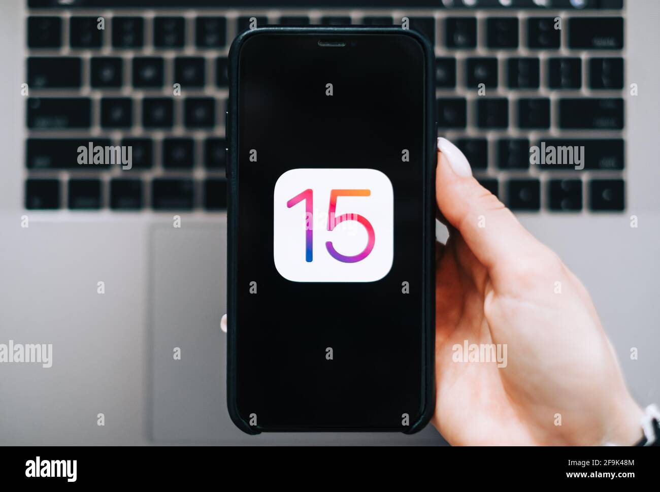 iPhone with iOS 15 logo on the screen close up, new operating system ...