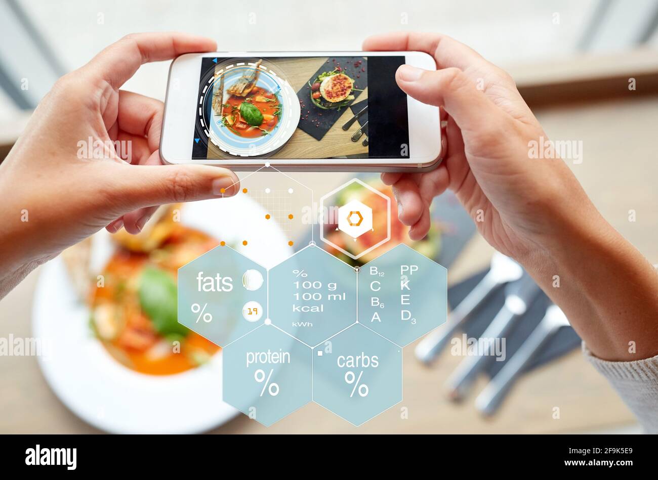 hands with phone and food nutritional value chart Stock Photo - Alamy