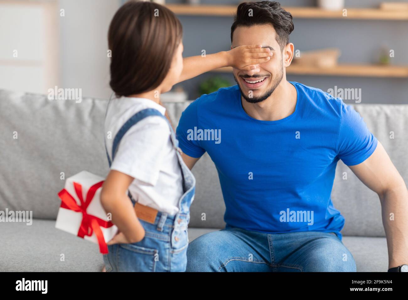 Girl celebrating father's day, greeting excited dad with box Stock ...