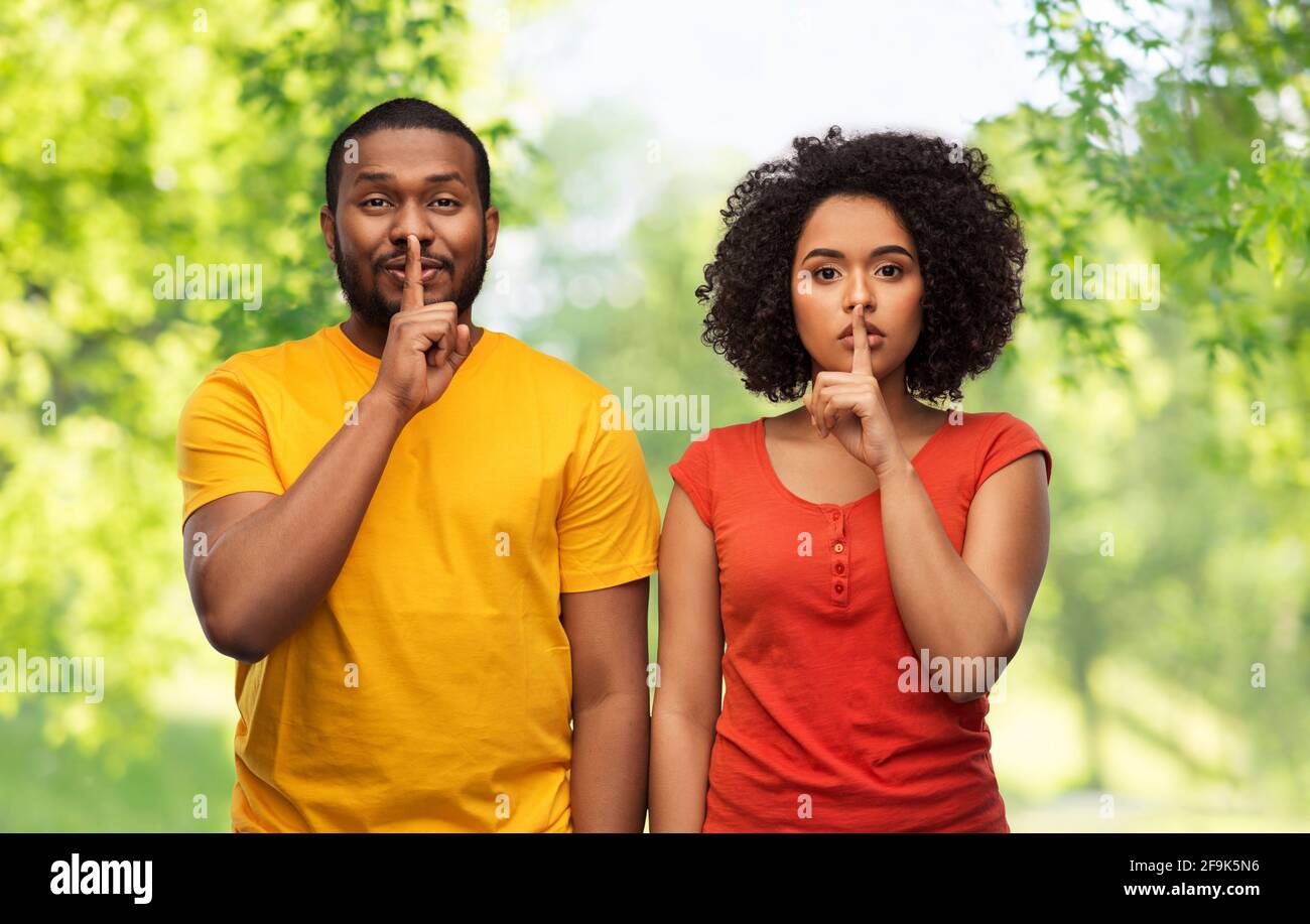 happy african american couple making hush gesture Stock Photo - Alamy