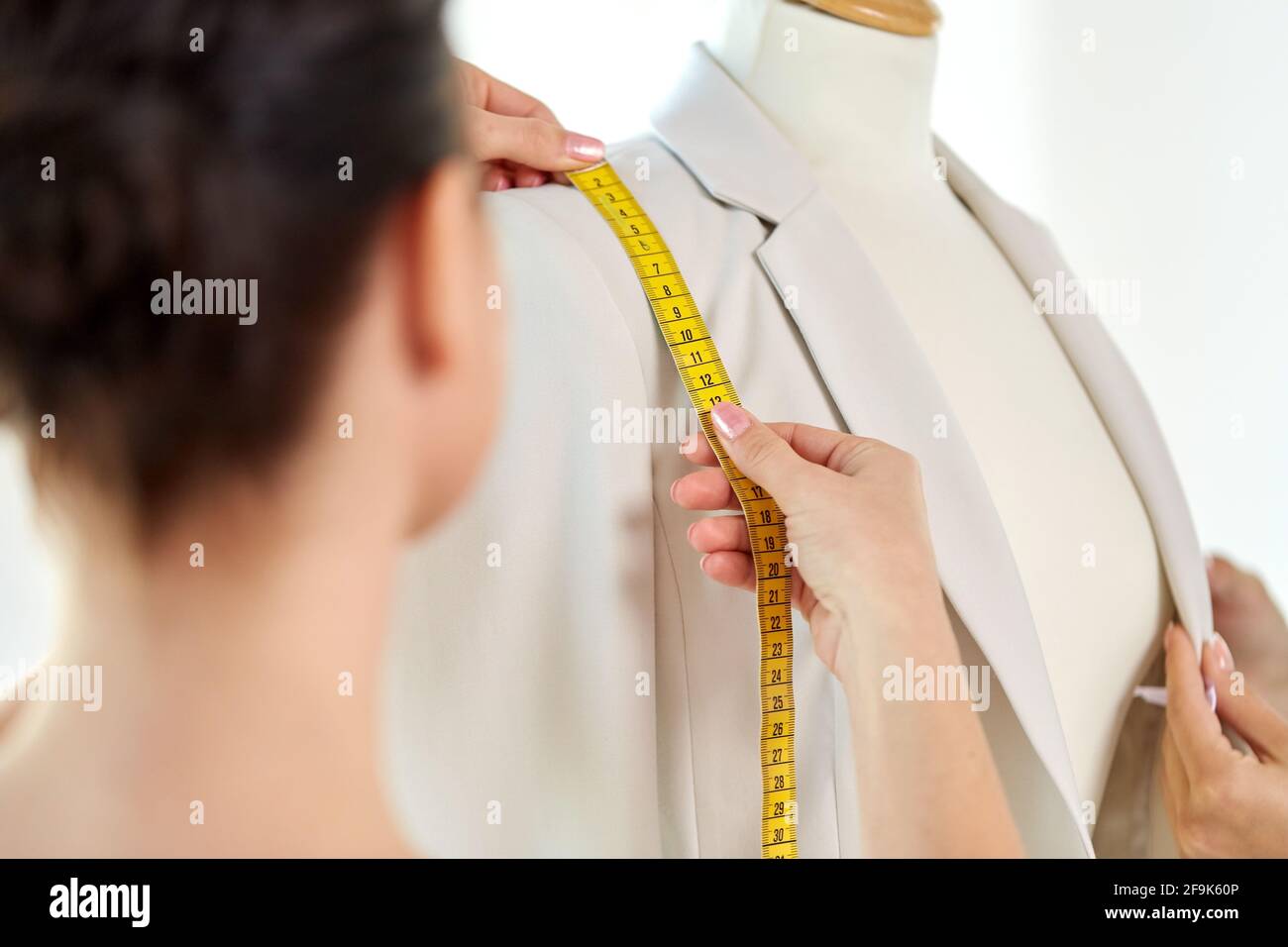 fashion designer measures jacket with tape measure Stock Photo - Alamy