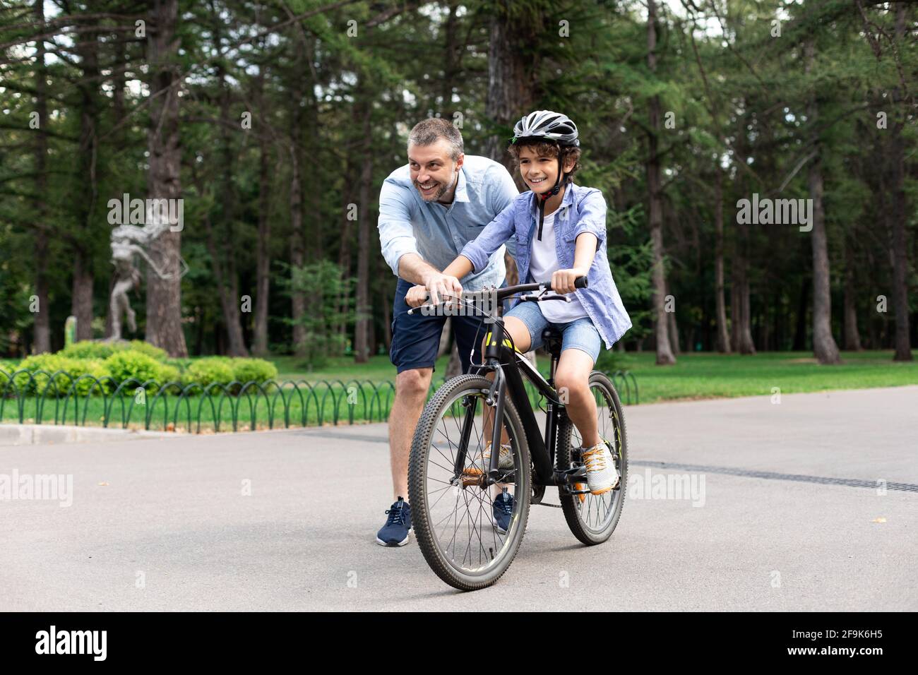Boy learning how to ride bicycle with his happy dad Stock Photo - Alamy