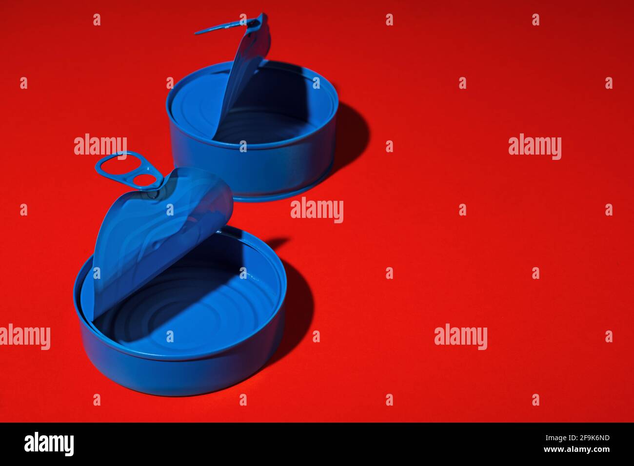Blue tin can on dark red background Stock Photo - Alamy