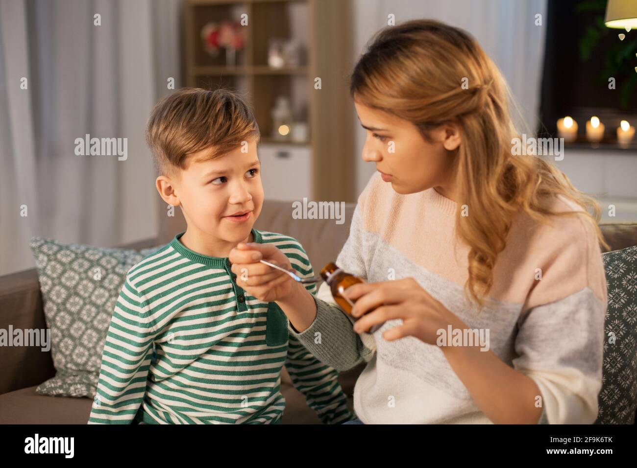 mother giving medication or cough syrup to ill son Stock Photo - Alamy