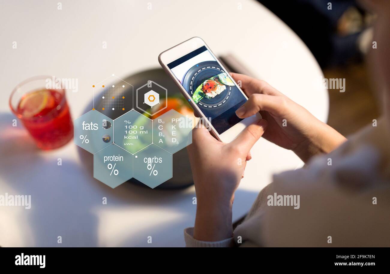 hands with phone and food nutritional value chart Stock Photo - Alamy