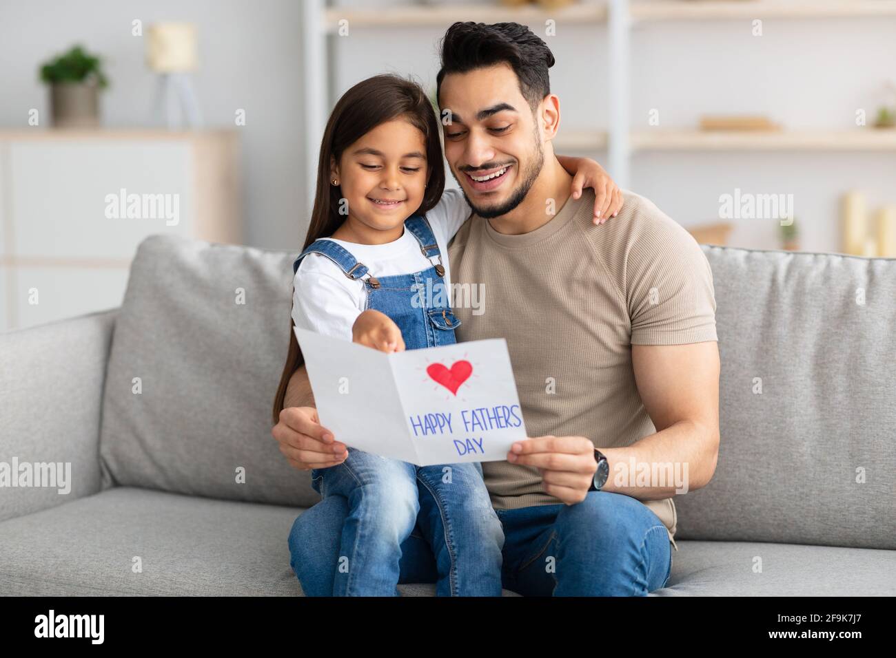 Little daughter greeting young excited dad with card Stock Photo - Alamy