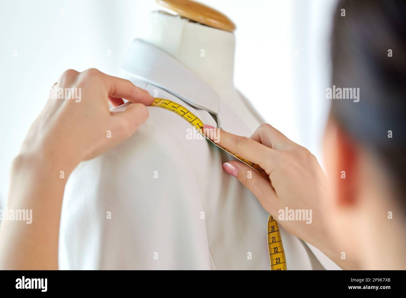 fashion designer measures jacket with tape measure Stock Photo - Alamy