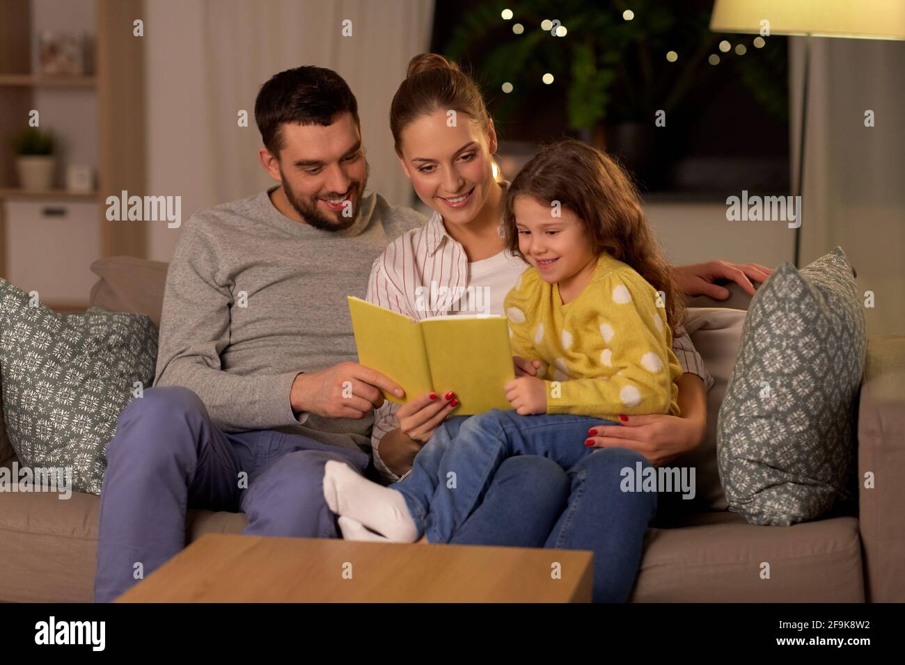 happy family reading book at home at night Stock Photo - Alamy