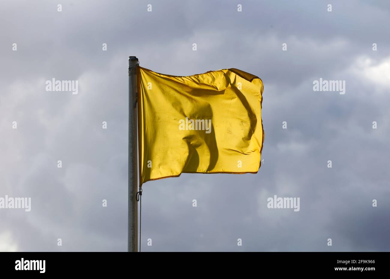 yellow flag flies in the air with clouds rainy day Stock Photo - Alamy
